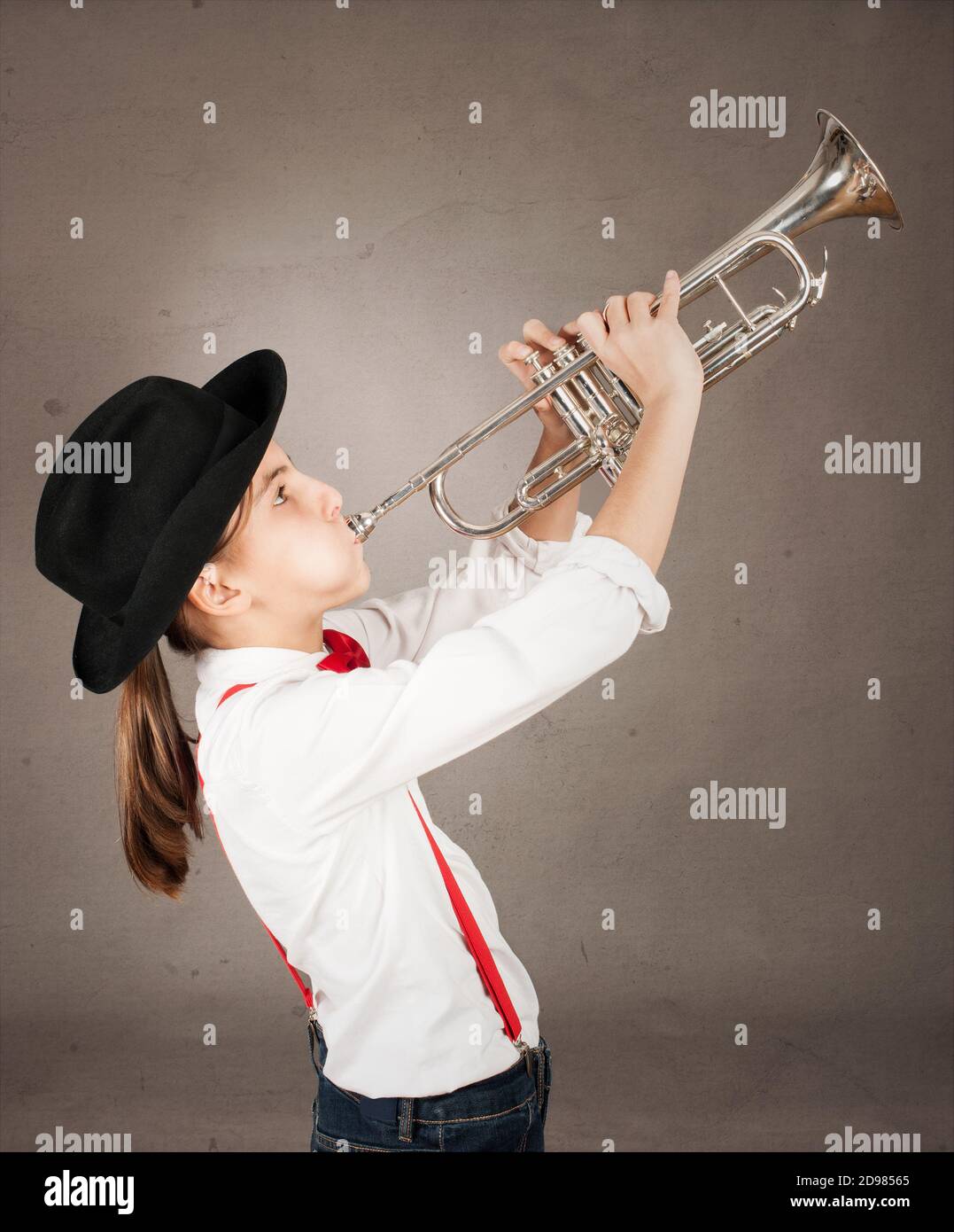 little girl playing trumpet on a gray background Stock Photo - Alamy