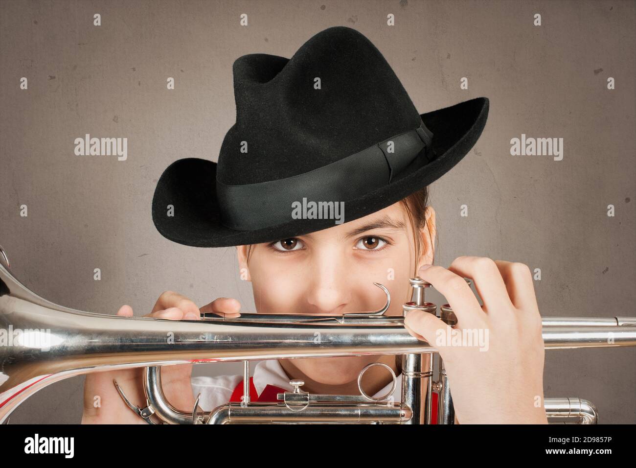 little girl playing trumpet on a gray background Stock Photo - Alamy