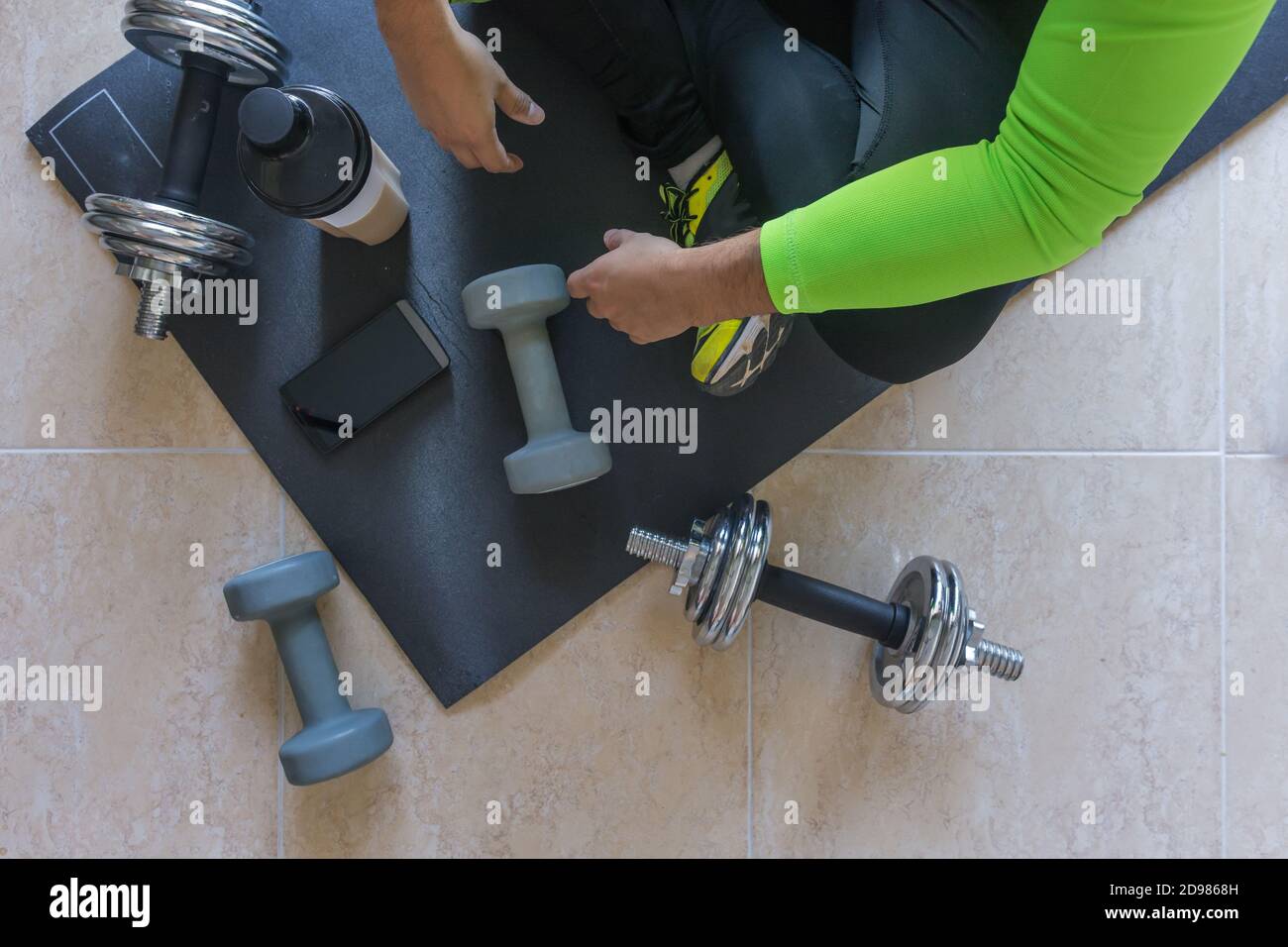 Dumbbell and mat training at home, and to drink a protein shake Stock ...