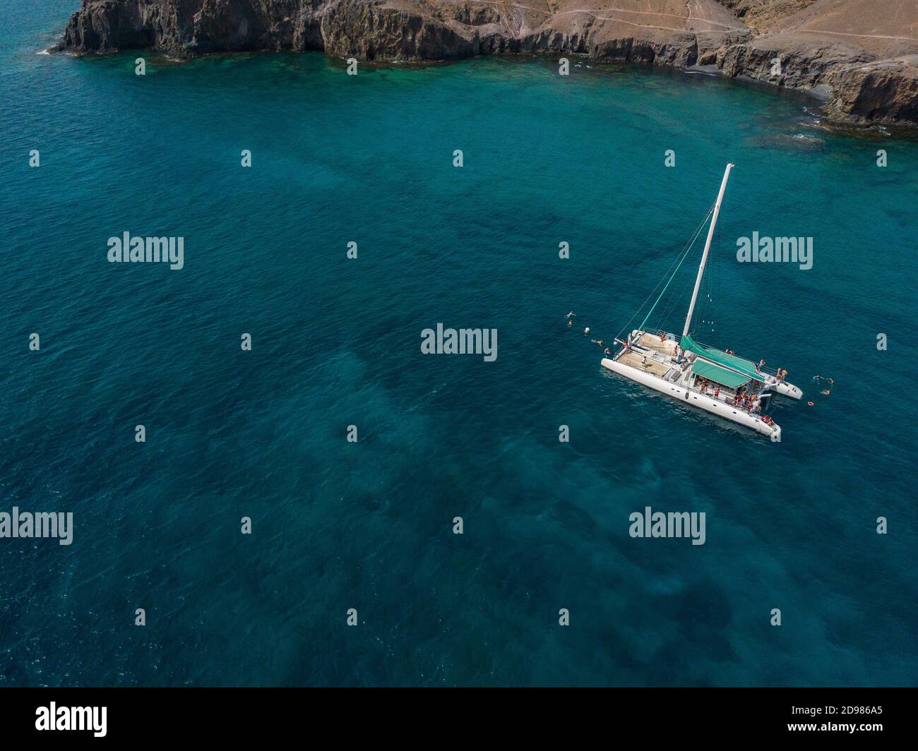 Aerial view of a catamaran with people on board and in the sea ...