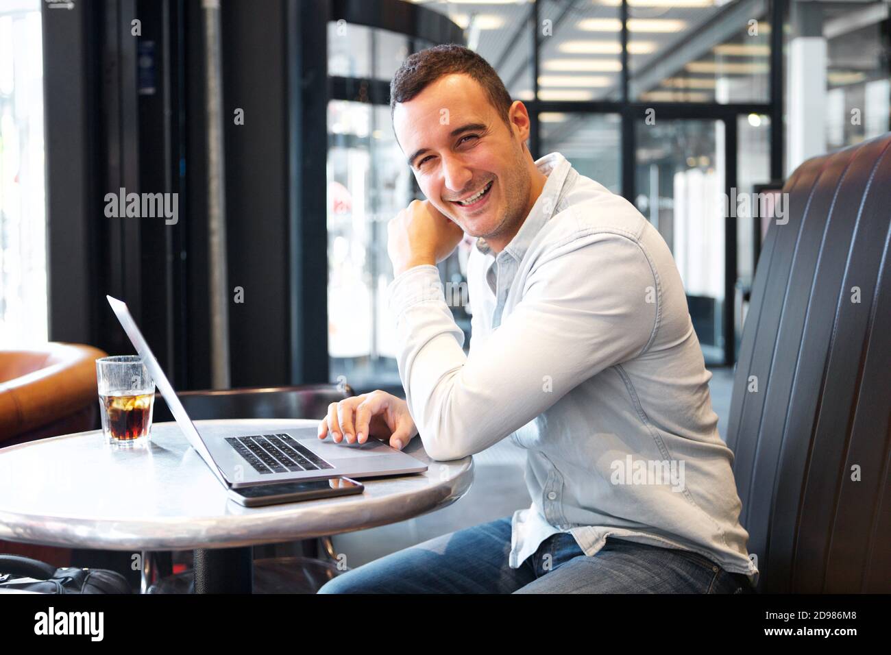 Side portrait of happy man sitting at cafe with laptop computer Stock ...
