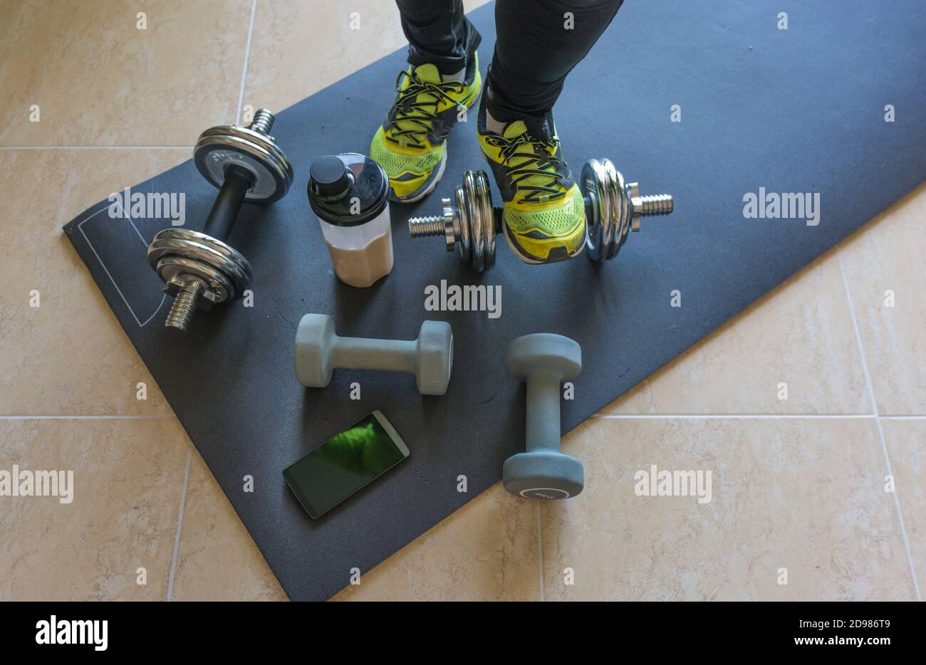 Dumbbell and mat training at home, and to drink a protein shake Stock ...