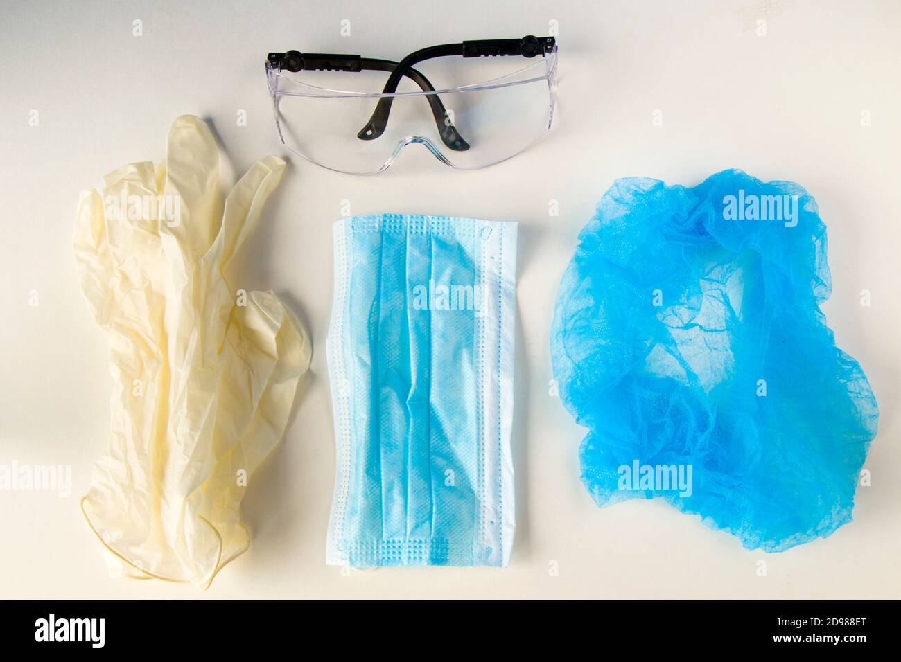 Medical gloves, face masks and safety glasses on the white background ...