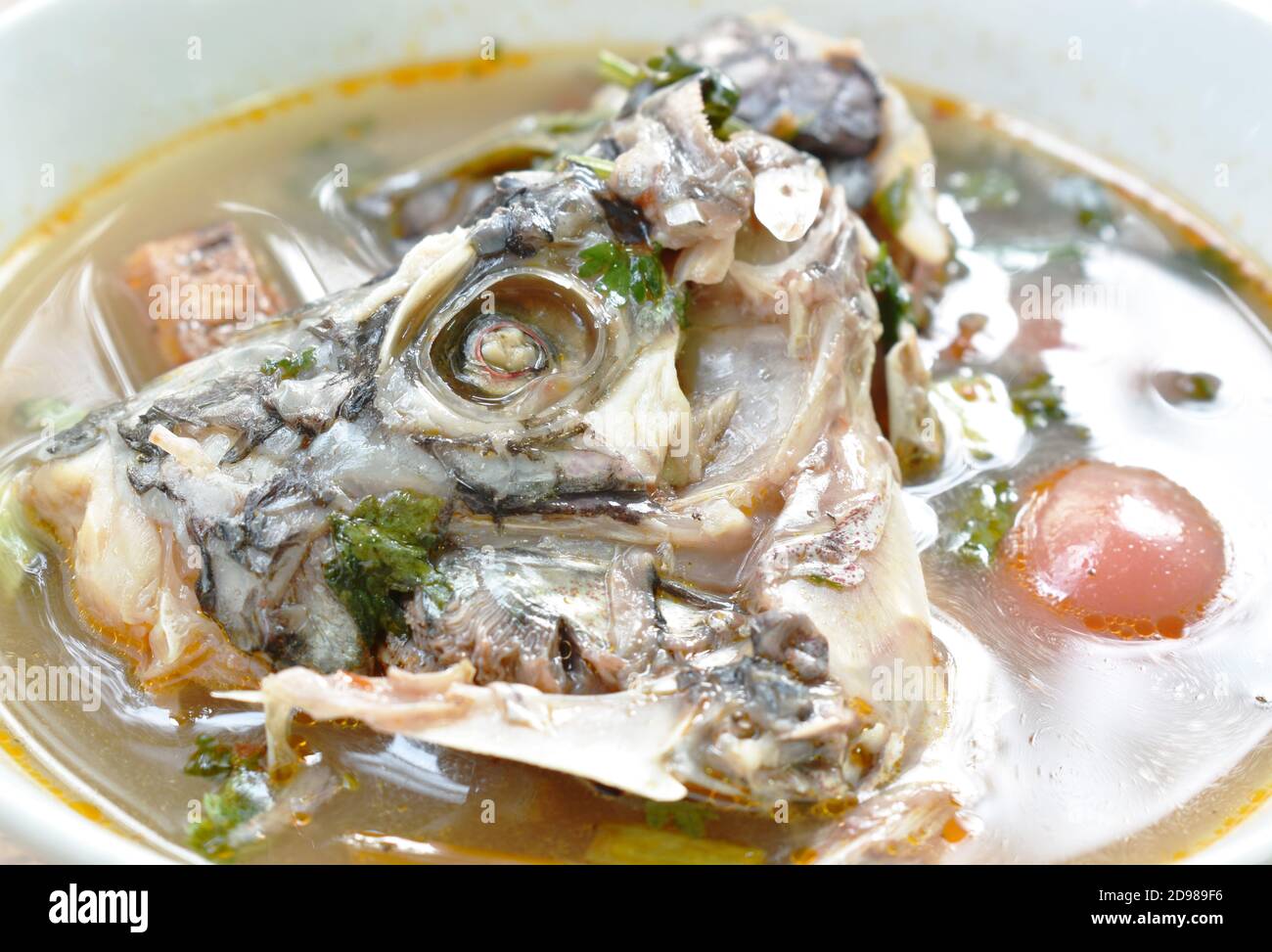spicy boiled Tilapia head fish in tom yum soup on bowl Stock Photo - Alamy