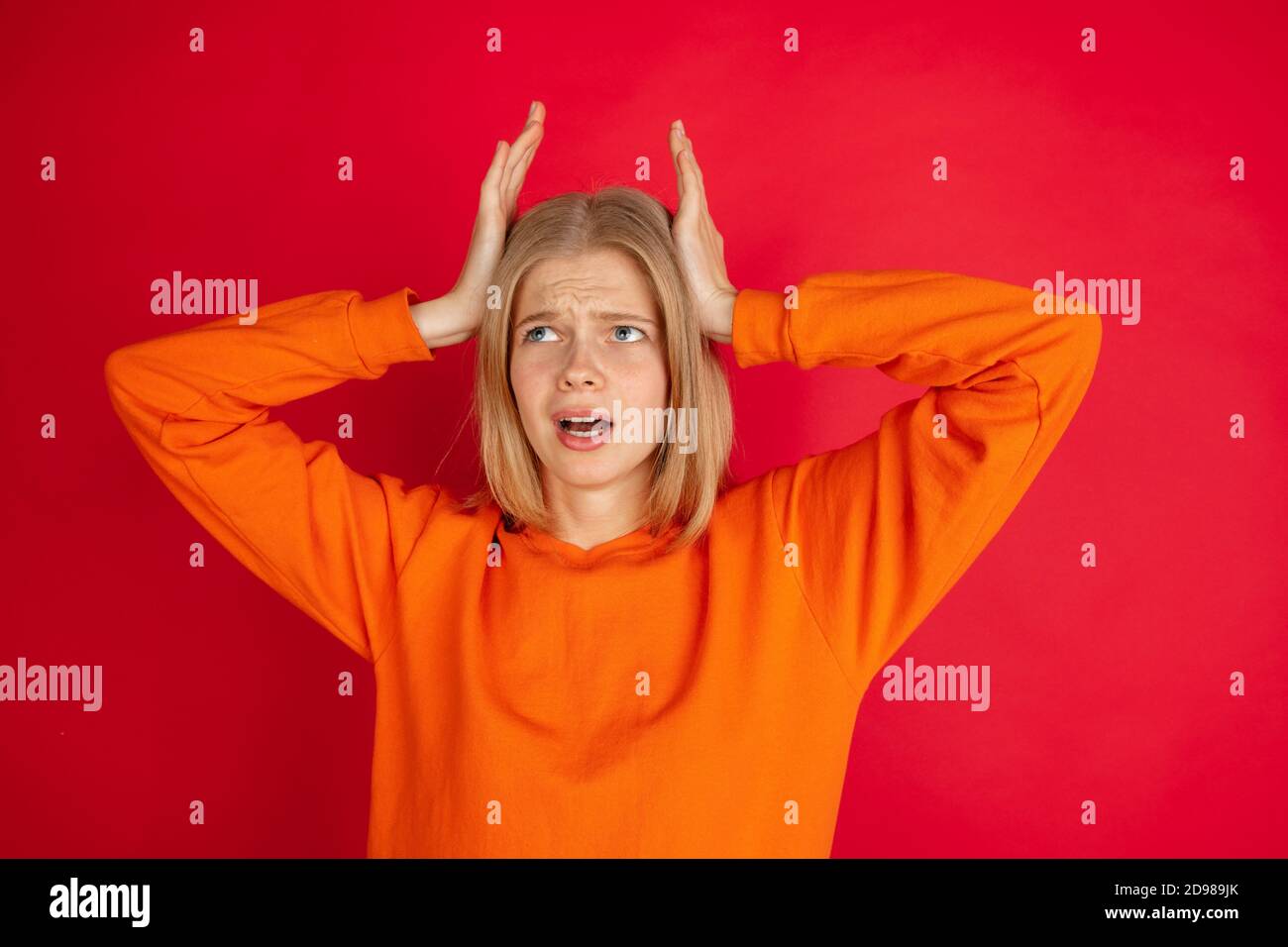 Angry holding head in hands. Portrait of young caucasian woman isolated ...