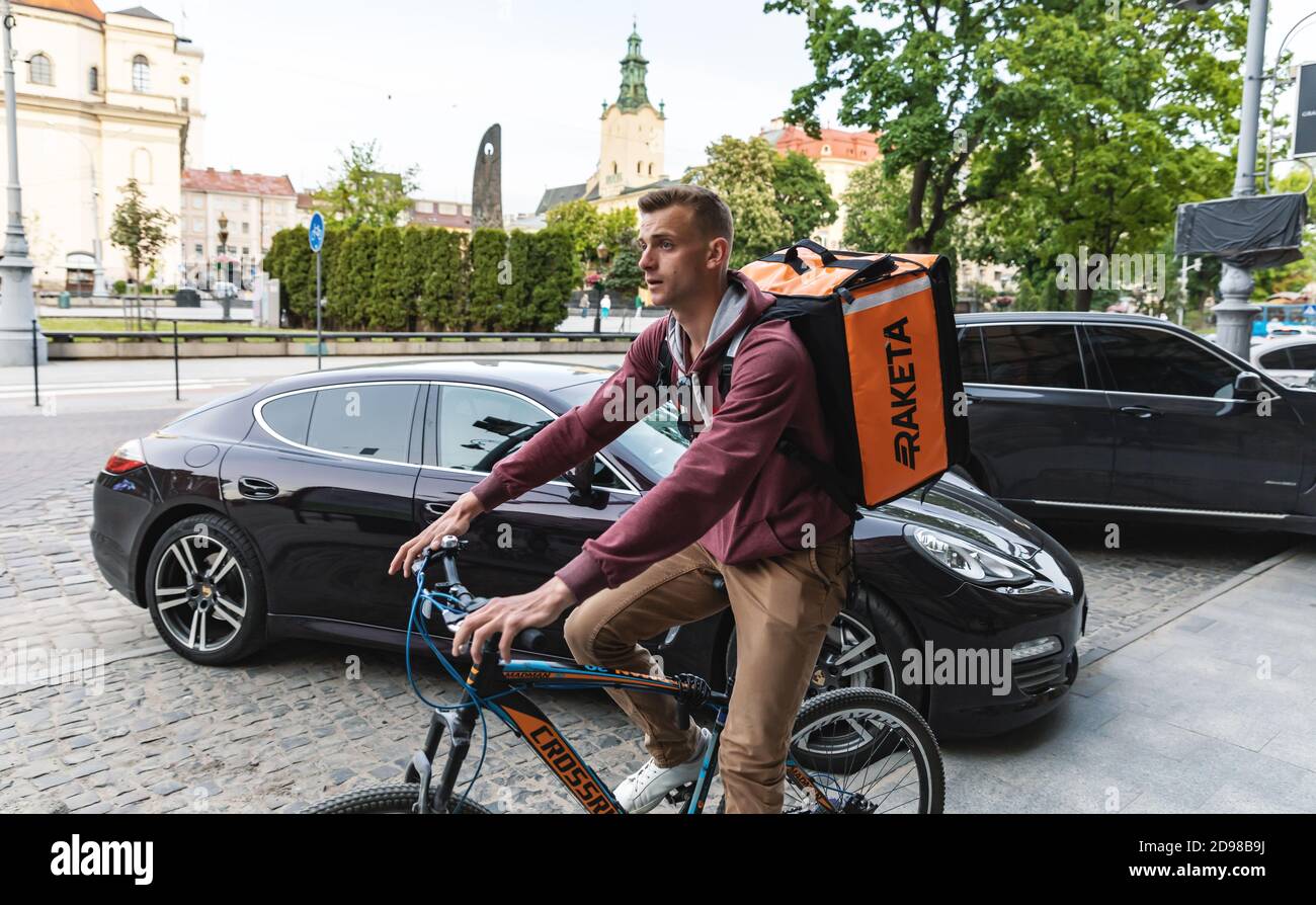 Lviv, Ukraine - May 25, 2020: A Raketa food delivery courier delivers ...