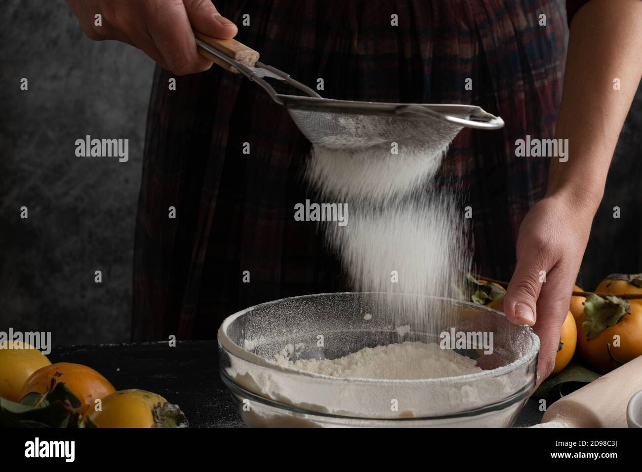 Woman sifting flour through sieve, preparing homemade sweet pie with ...