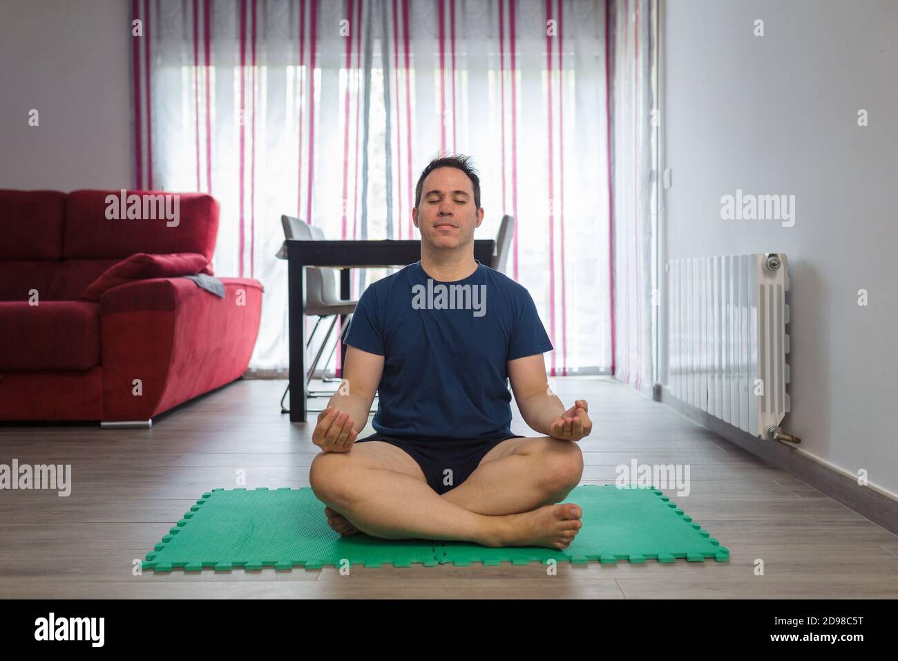 relaxed Caucasian man in yoga meditation position, feet crossed, eyes ...