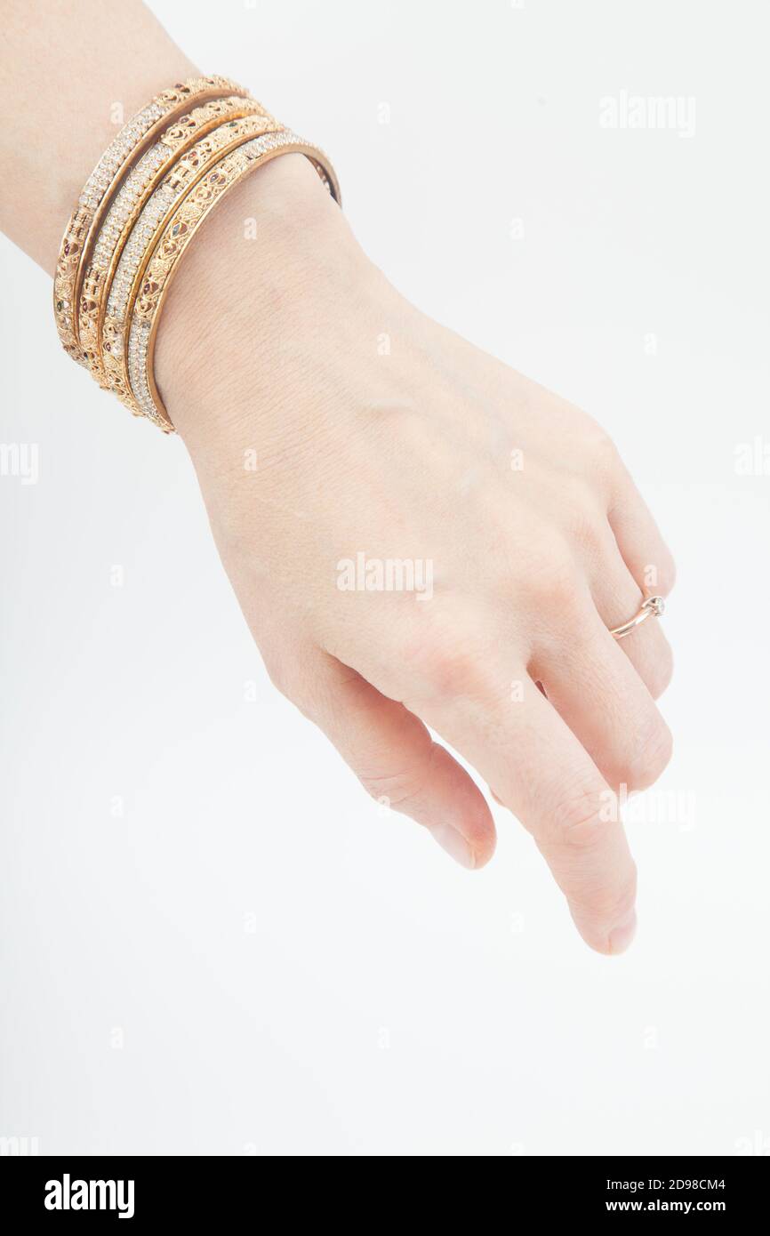 Female hand with set of golden bracelets on white background Stock ...