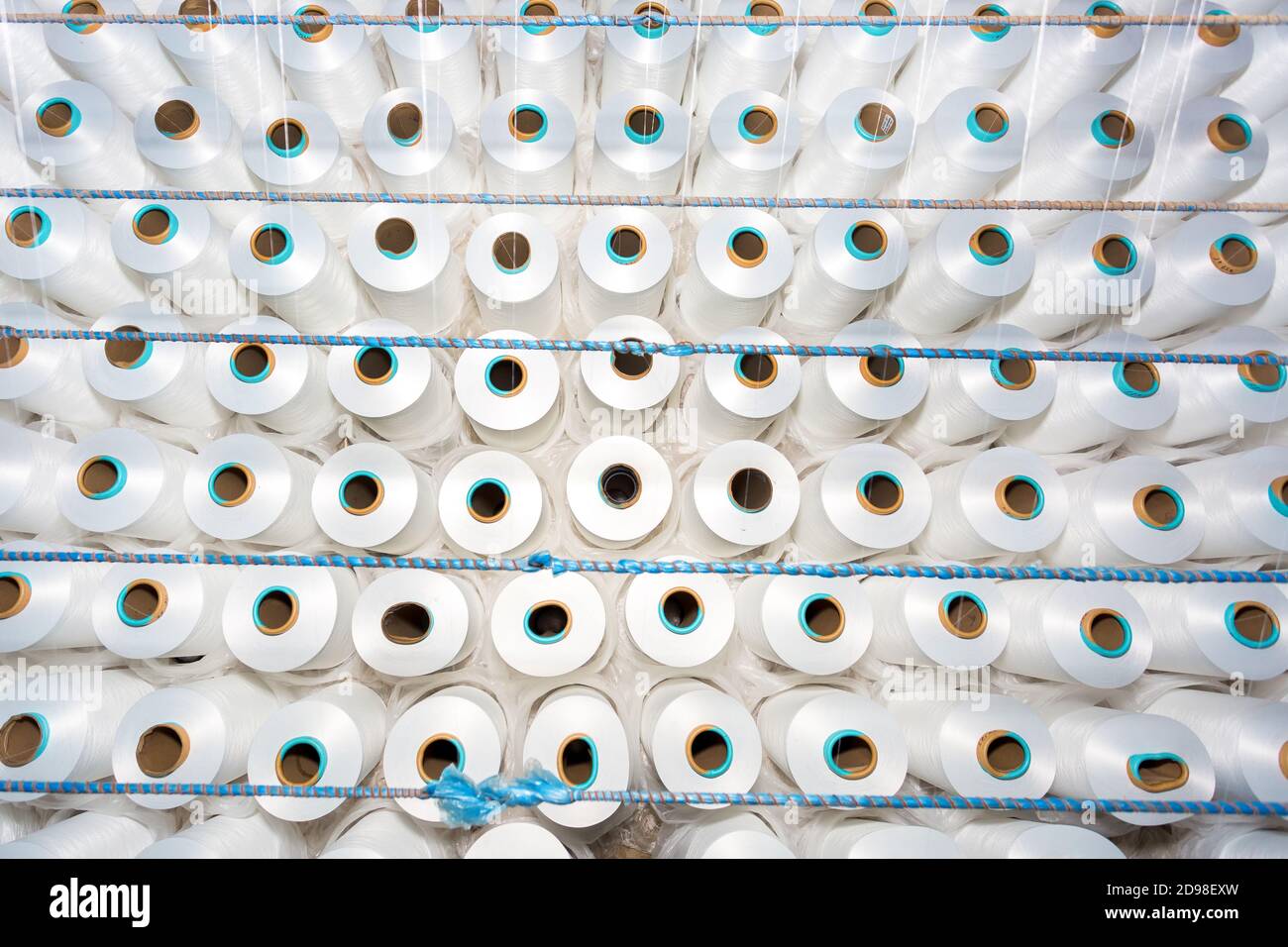 Top view of A lot of white yarn spools in a textile factory. White yarn ...