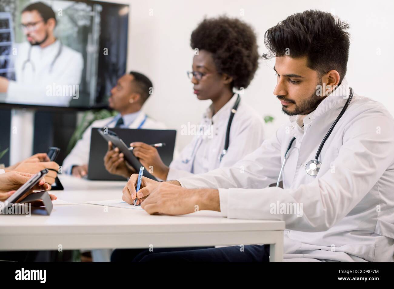 Group of multiethnic male and female medical doctors using clipboards ...