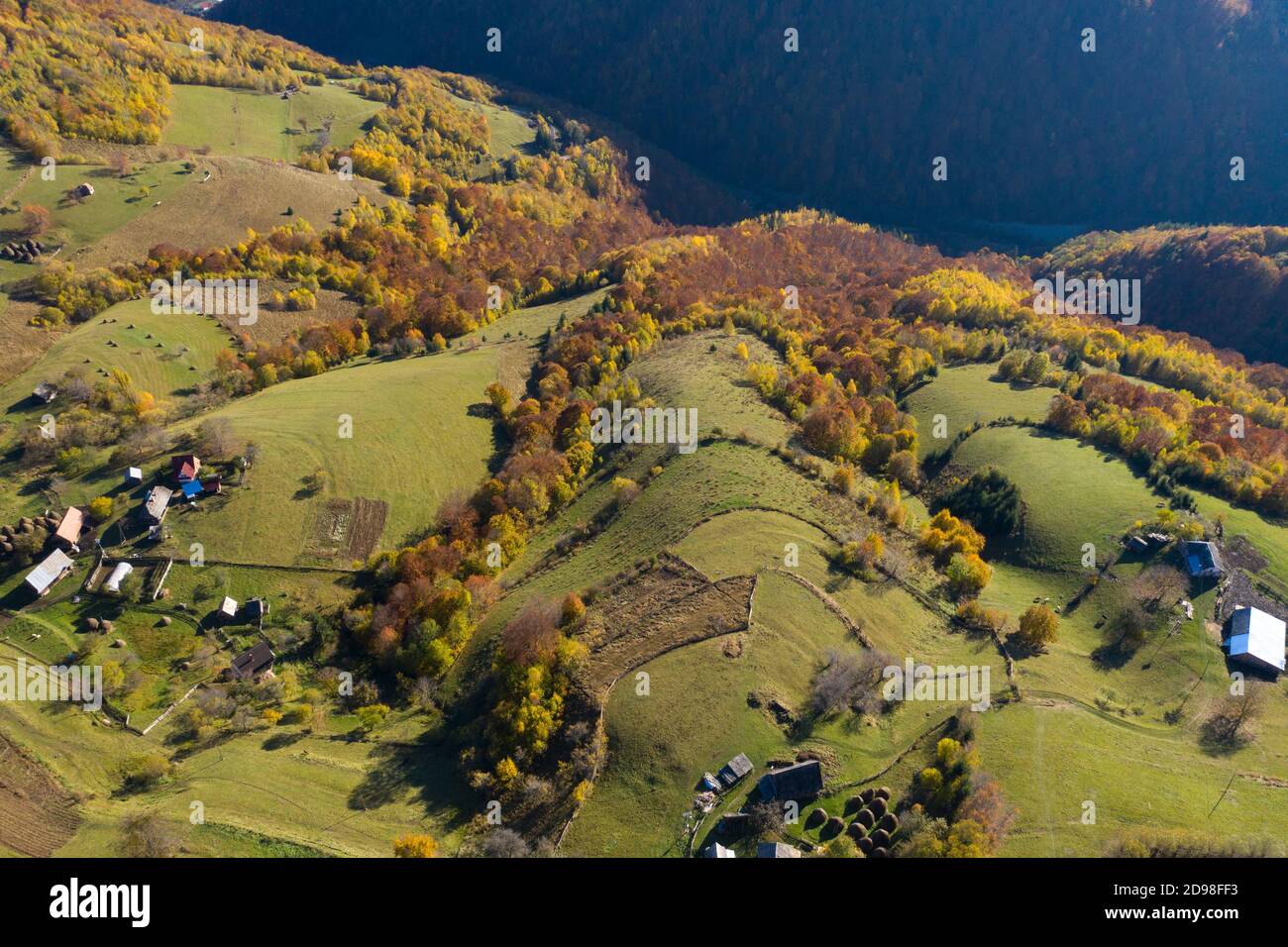Aerial view of a small countryside homestead and colorful autumn forest ...