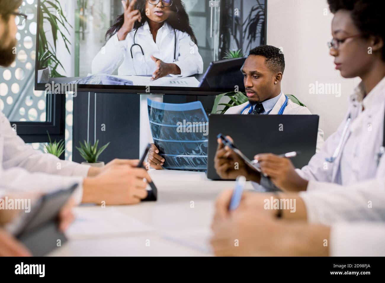 Team of confident multiethnic doctors having video conference meeting ...