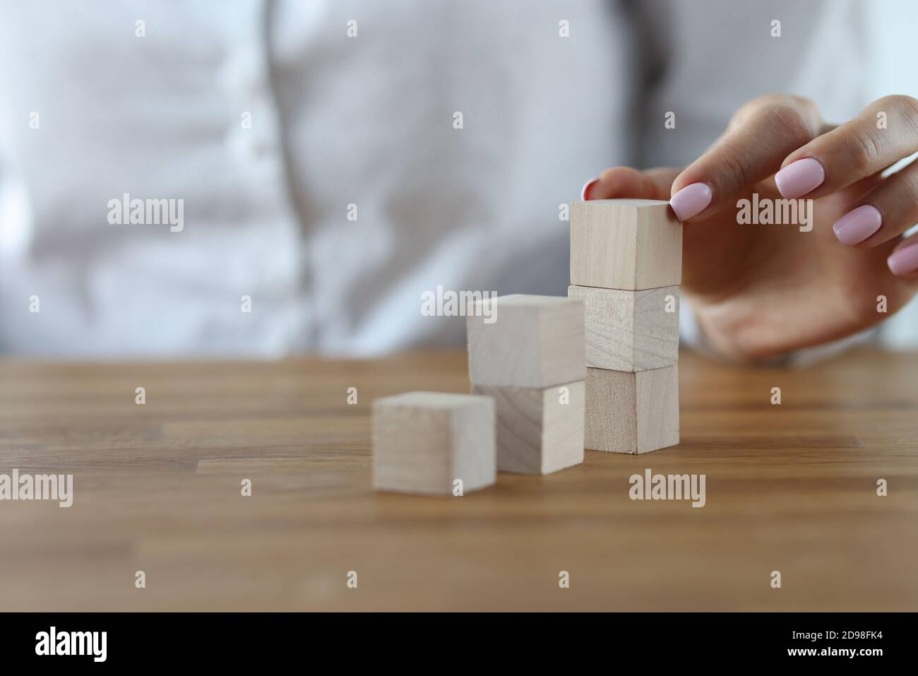 Female hand builds tower from wooden blocks Stock Photo - Alamy