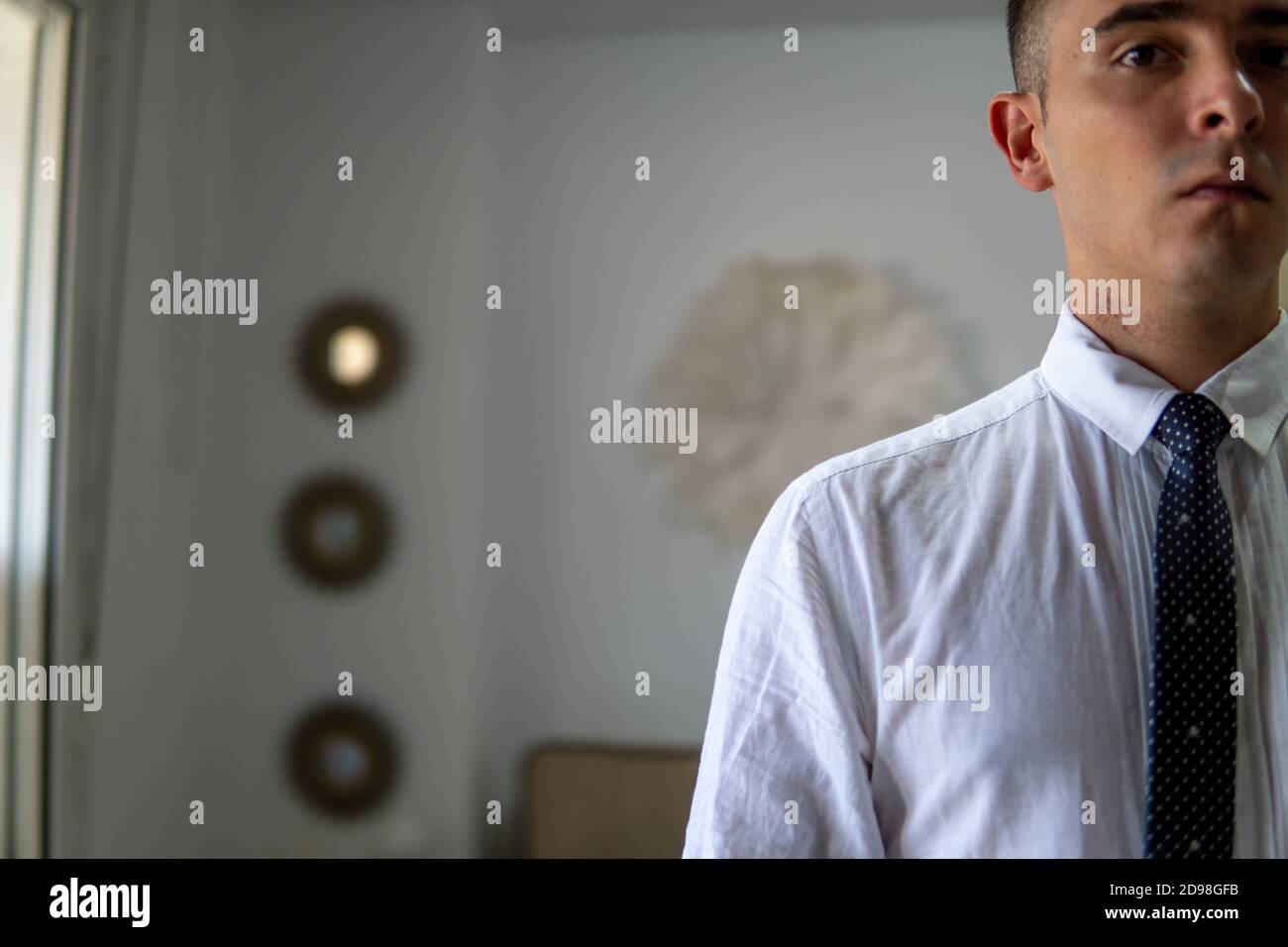 Young businessman poses in front of the camera with a serious and ...