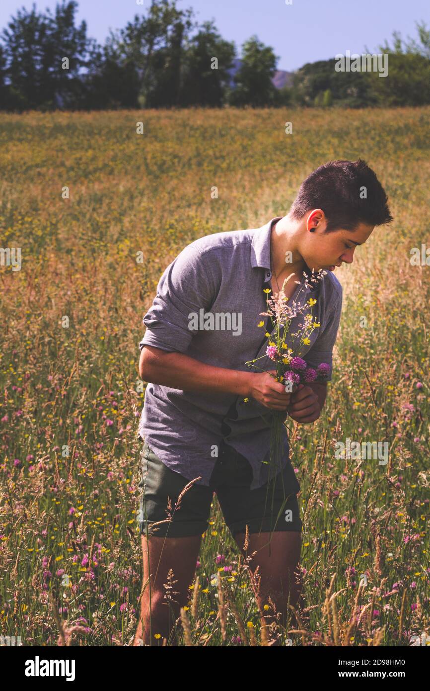 Young man collecting flowers for his lover Stock Photo - Alamy
