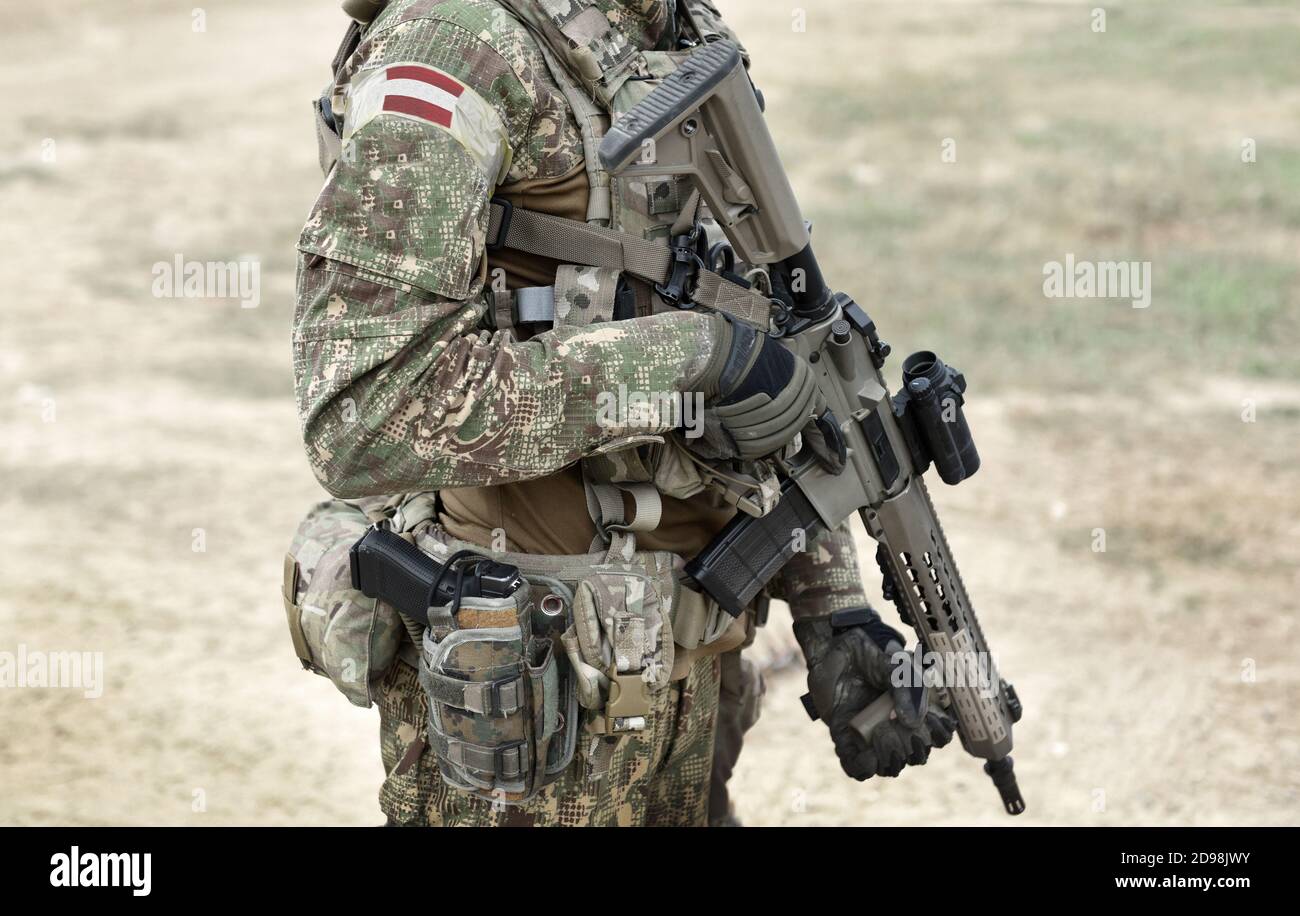 Soldier with assault rifle and flag of Austria on military uniform ...