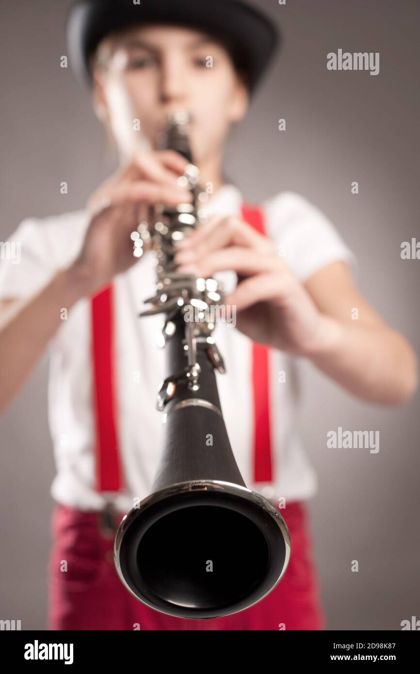 little girl playing clarinet on a gray background Stock Photo - Alamy