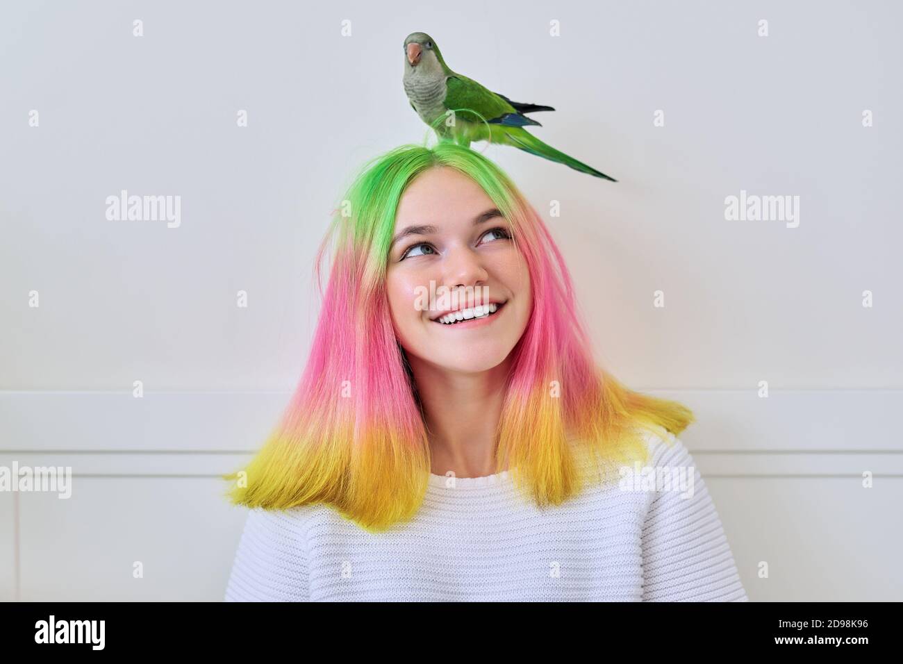 Trendy fashionable with colored hairstyle teenager with green parrot on ...