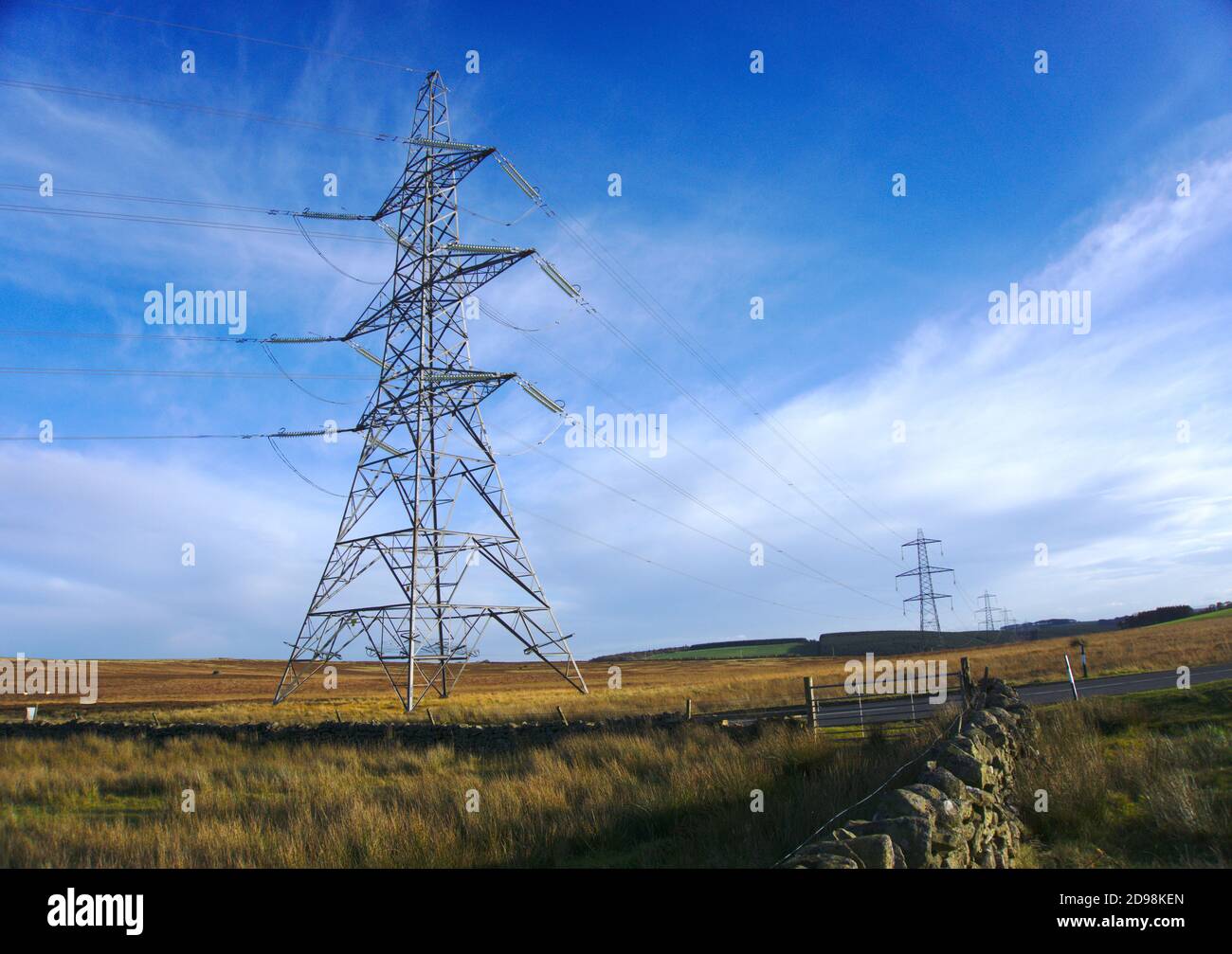 Electricity pylons stretching into the distance across moorland in the ...