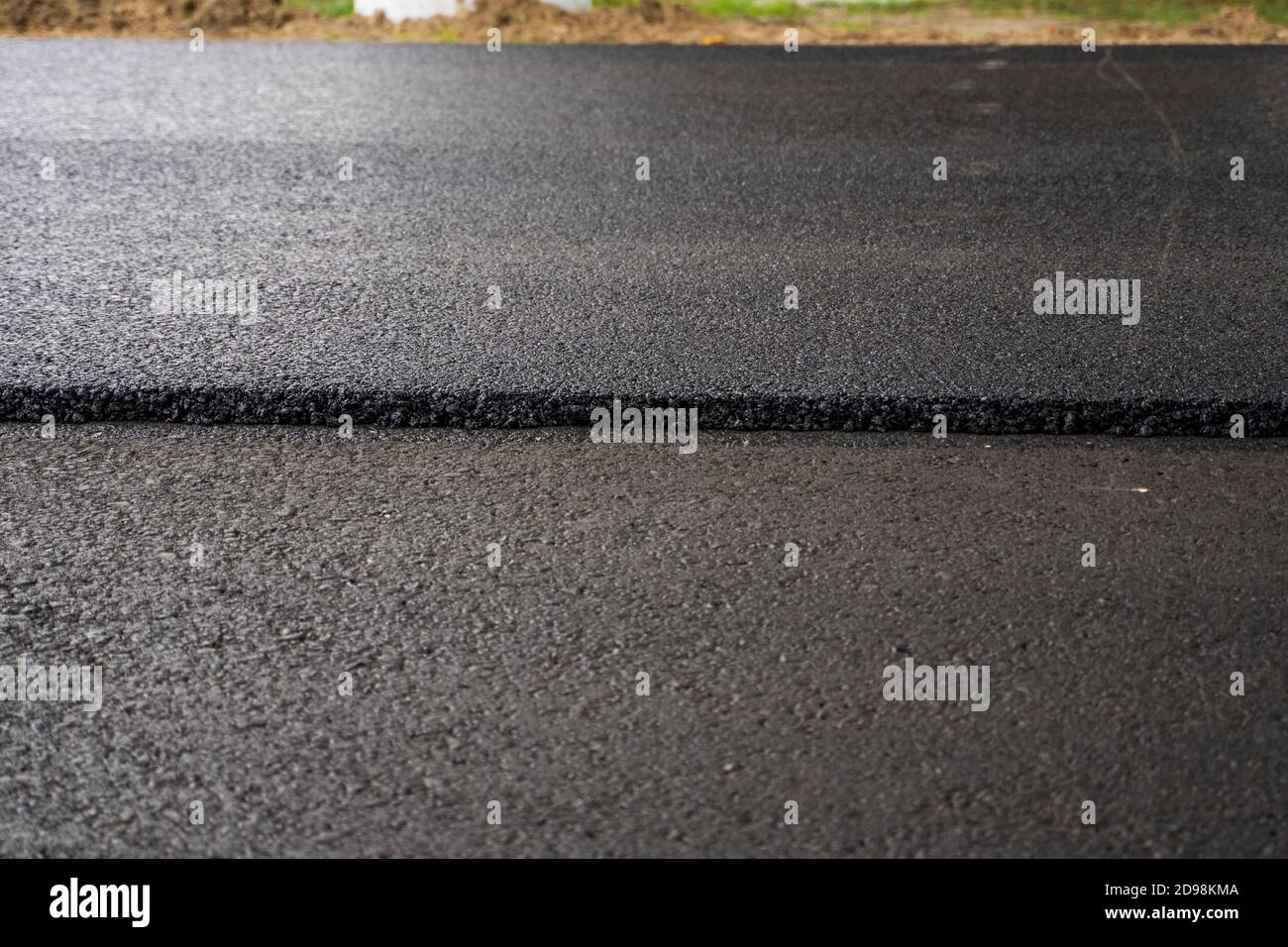 A large layer of fresh hot asphalt. Layer of asphalt raw material in a ...