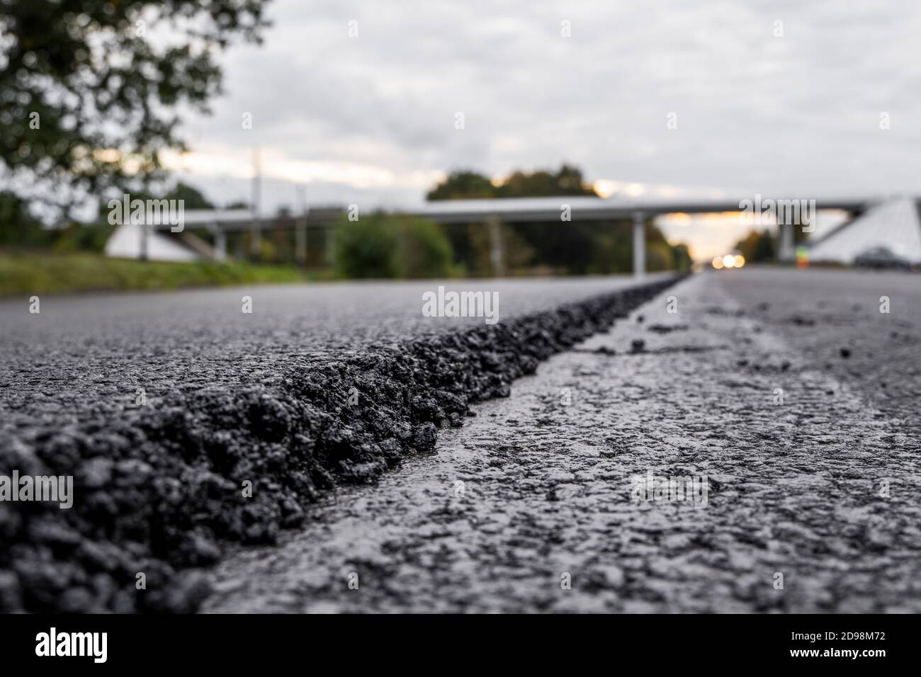 A large layer of fresh hot asphalt. Layer of asphalt raw material in a ...