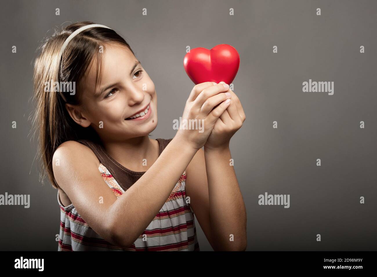 happy little girl holding red heart Stock Photo - Alamy