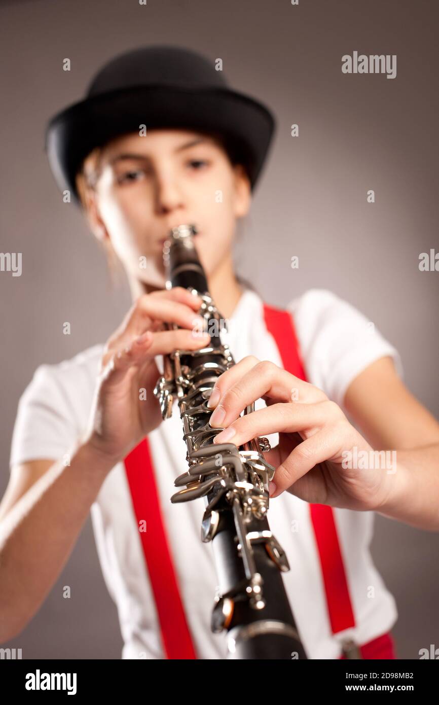little girl playing clarinet on a gray background Stock Photo - Alamy