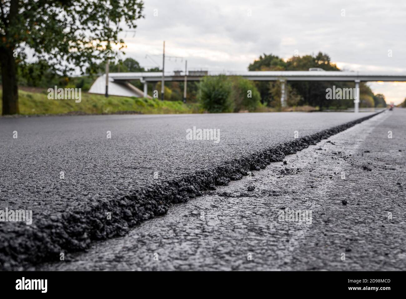 A large layer of fresh hot asphalt. Layer of asphalt raw material in a ...