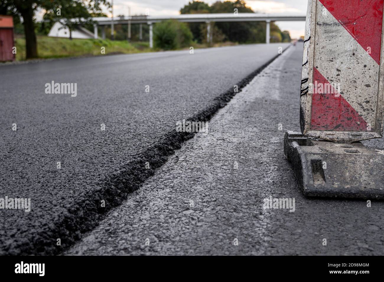 A large layer of fresh hot asphalt. Layer of asphalt raw material in a ...