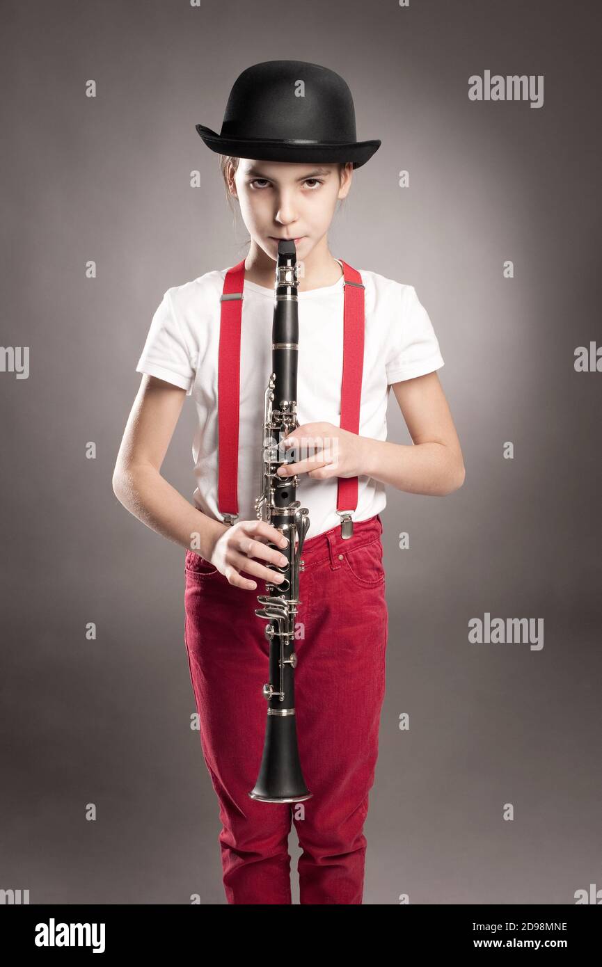 little girl playing clarinet on a gray background Stock Photo - Alamy