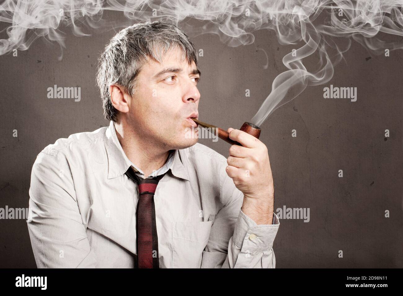 pensive middle aged man smoking with a pipe Stock Photo - Alamy