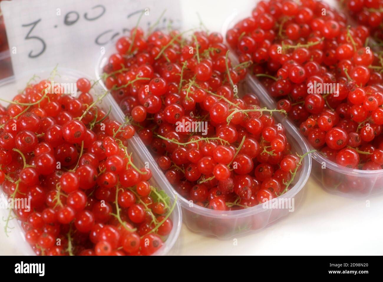 Three shells of red currant on market bench Stock Photo - Alamy