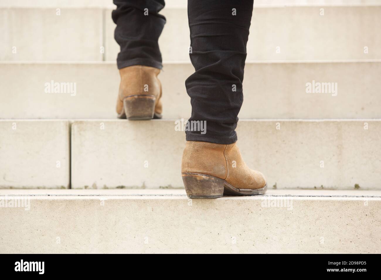 Close up rear view of man walking up stairs in boots Stock Photo - Alamy