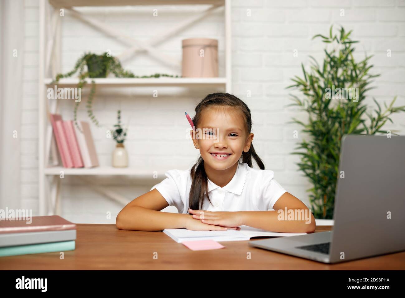 smiling little child girl using laptop for studying online learning ...