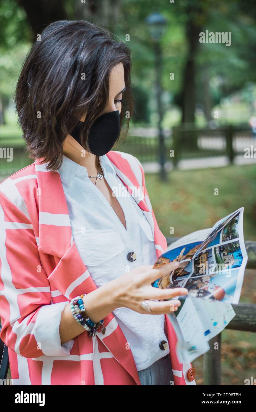 Woman holding a map and wearing a protective mask Stock Photo - Alamy
