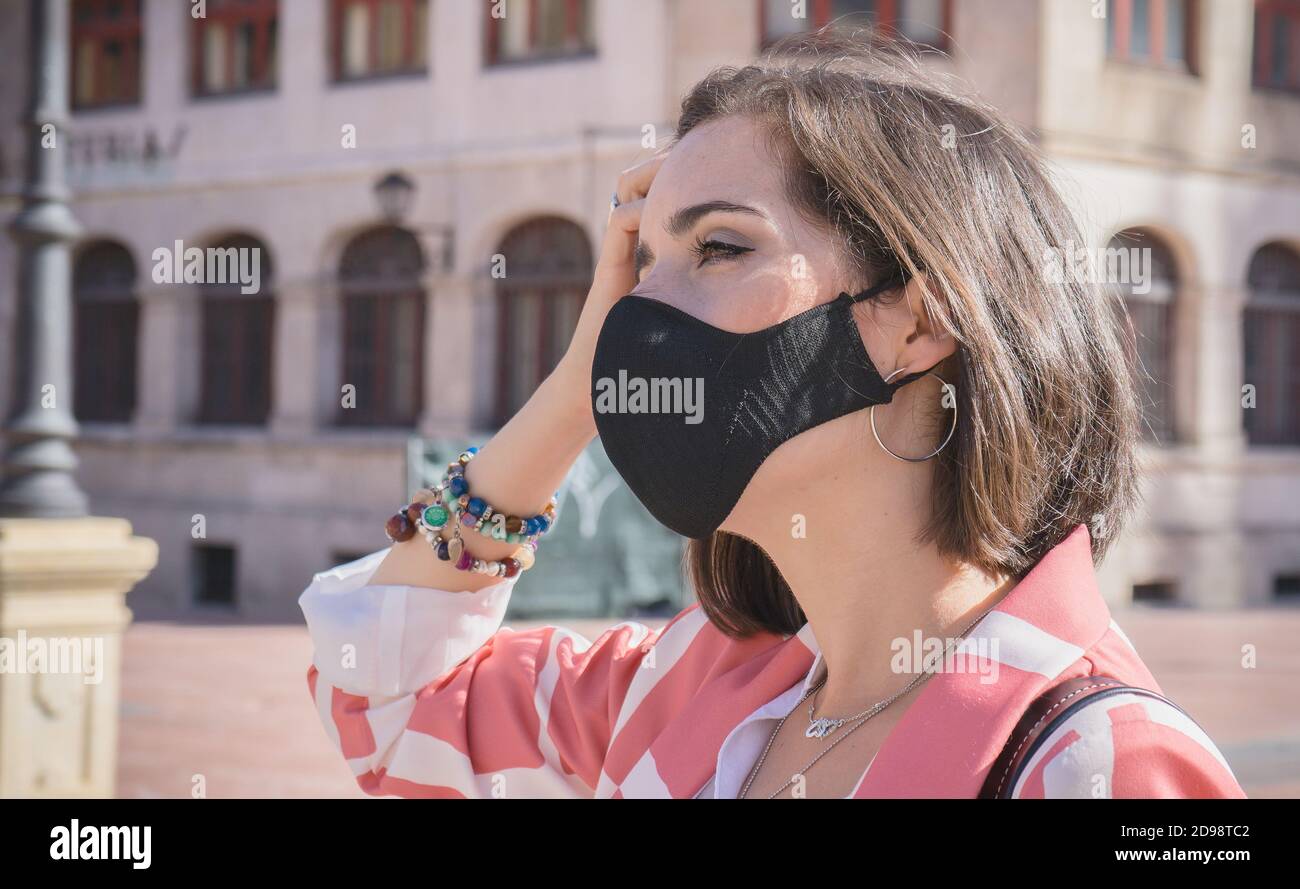 Woman posing and wearing a black protective mask Stock Photo - Alamy