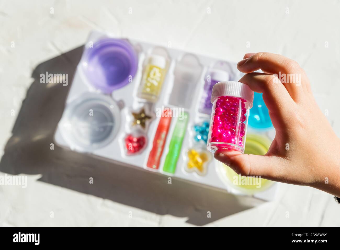 Child holding Ingredients, bottles, jars for making a popular children ...