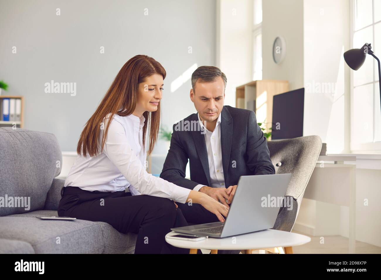 Two business people looking at laptop hi-res stock photography and ...