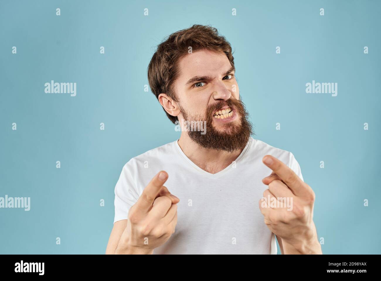 Bearded man in white T-shirt emotions gestures with hands displeased ...