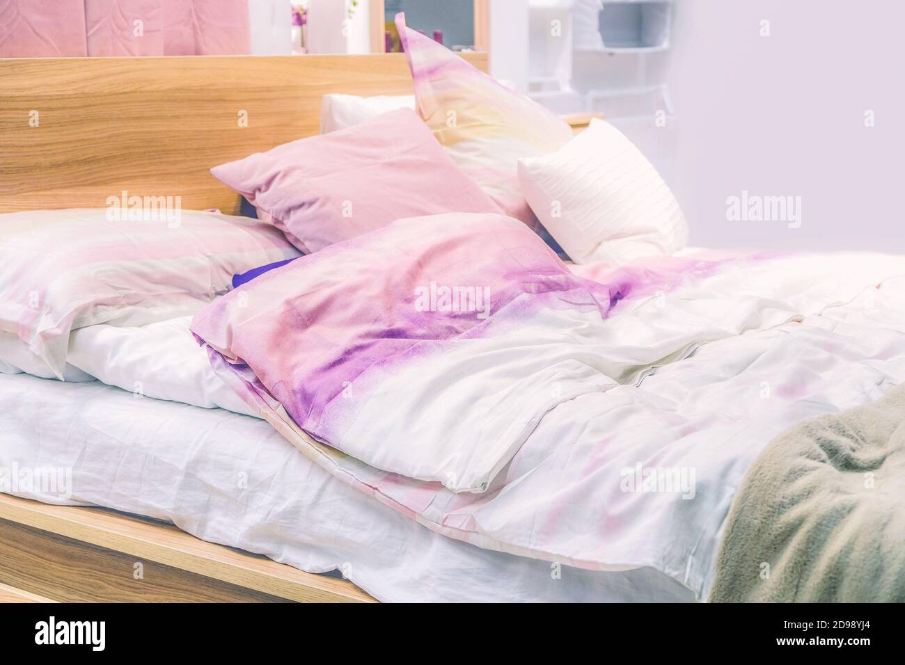 The bedclothes are crumpled. Pillows are scattered at the head of the ...