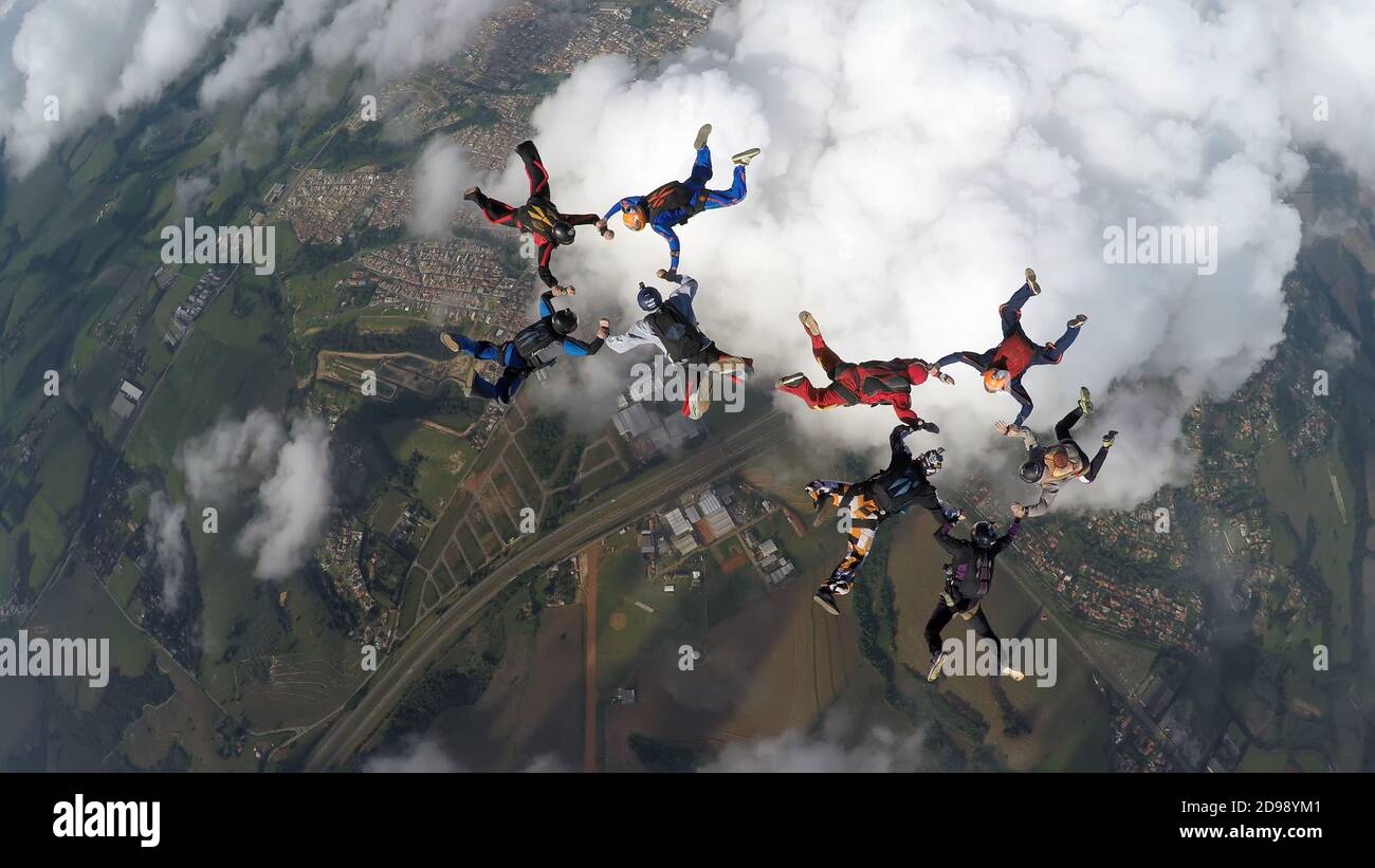 Skydiving friends holding hands Stock Photo - Alamy