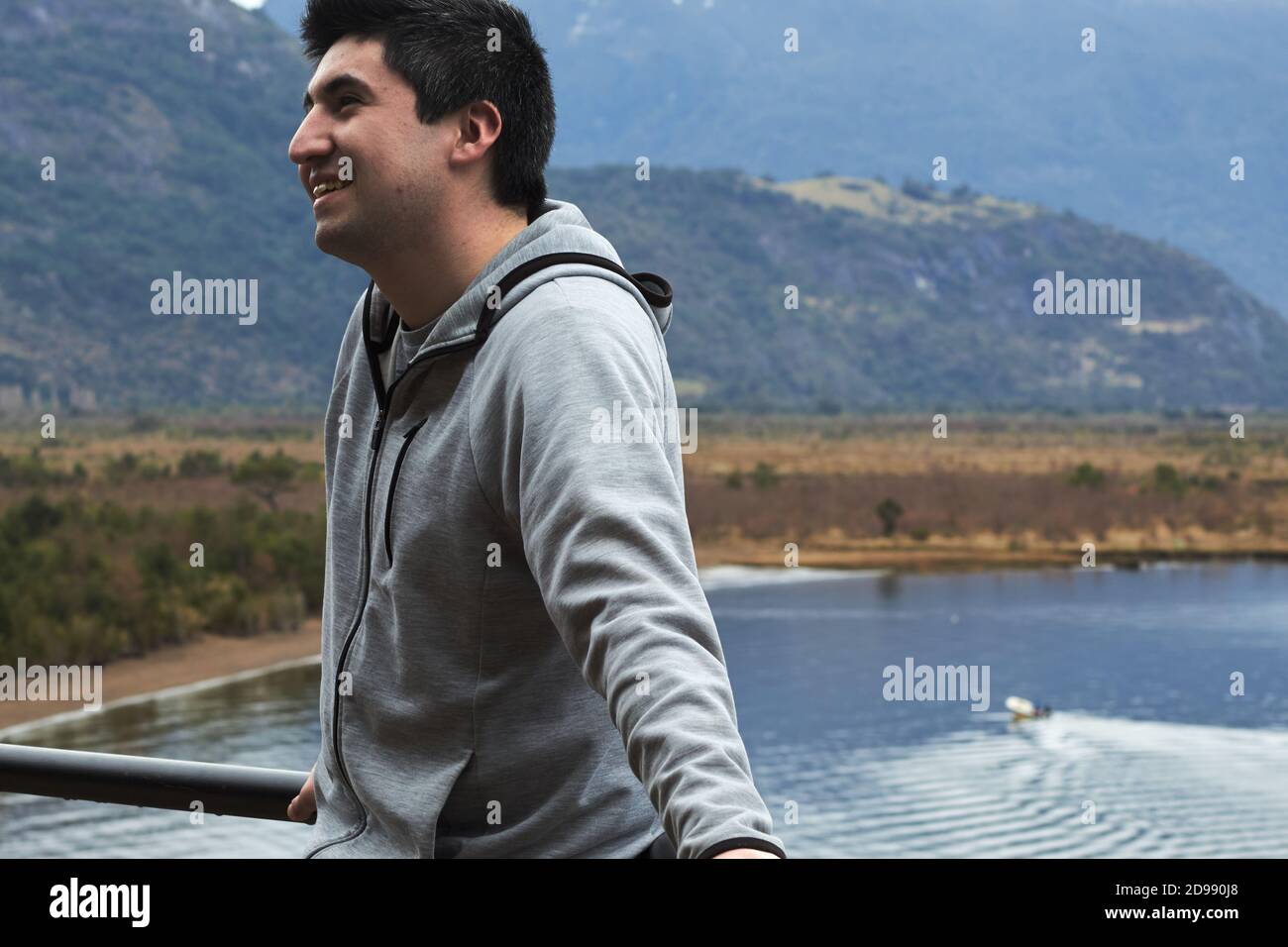 Shallow focus shot of a young male leaning on a railing and enjoying ...