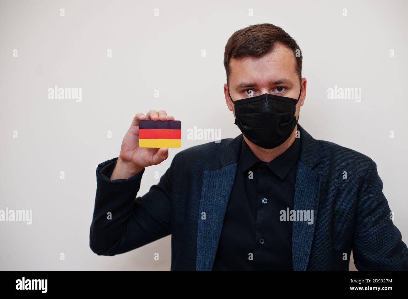 European man wear black formal and protect face mask, hold Germany flag ...