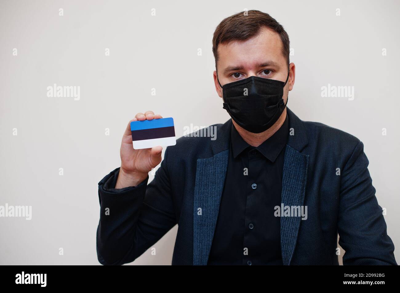 European man wear black formal and protect face mask, hold Estonia flag ...