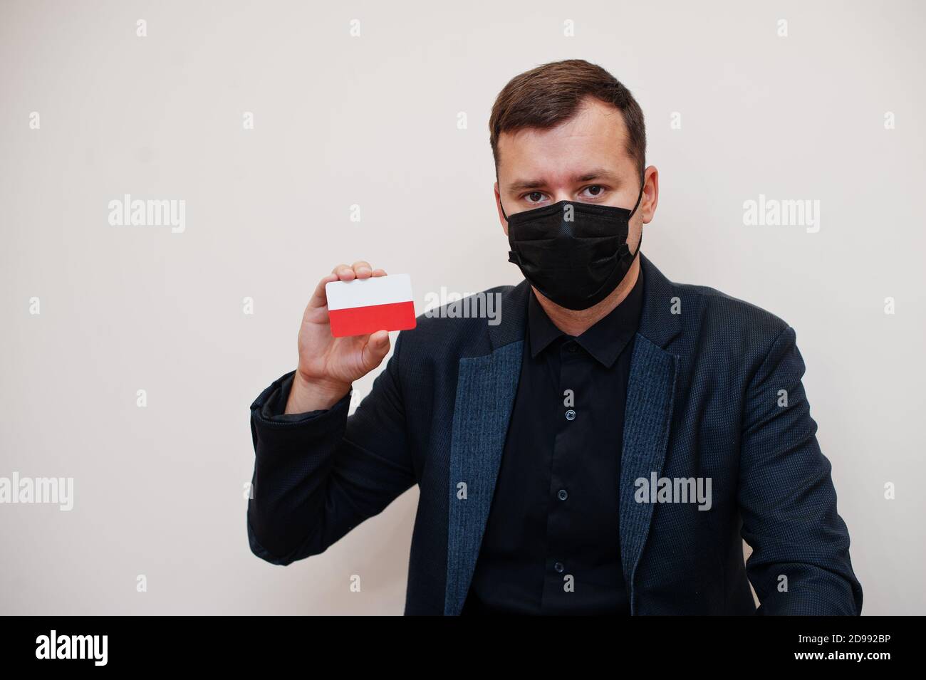 European man wear black formal and protect face mask, hold Poland flag ...