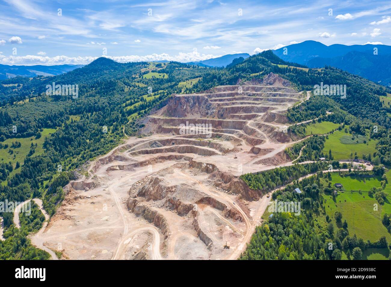 Aerial view of cement mining quarry, rock terraces and working trucks ...