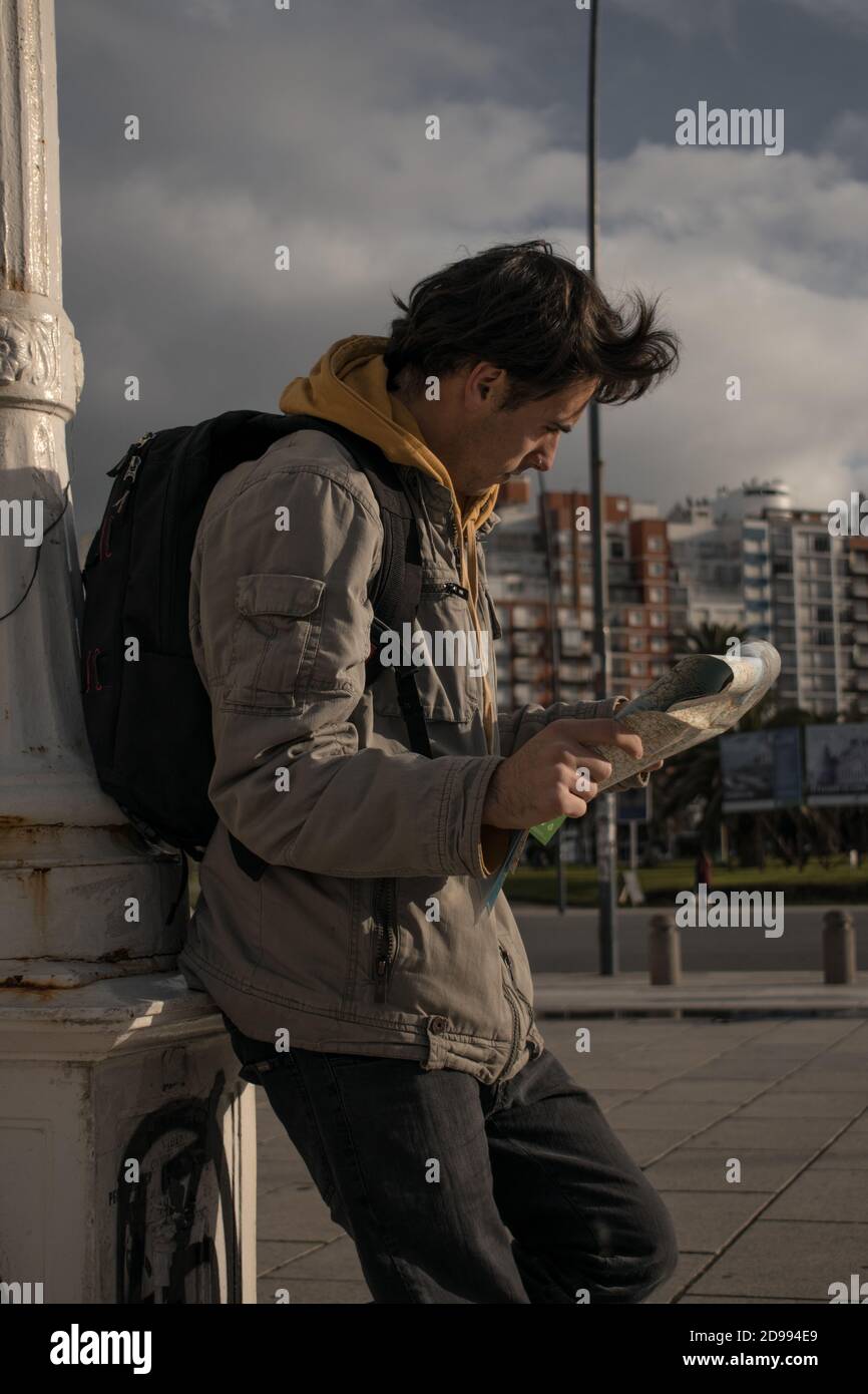 Young male tourist checking map hi-res stock photography and images - Alamy