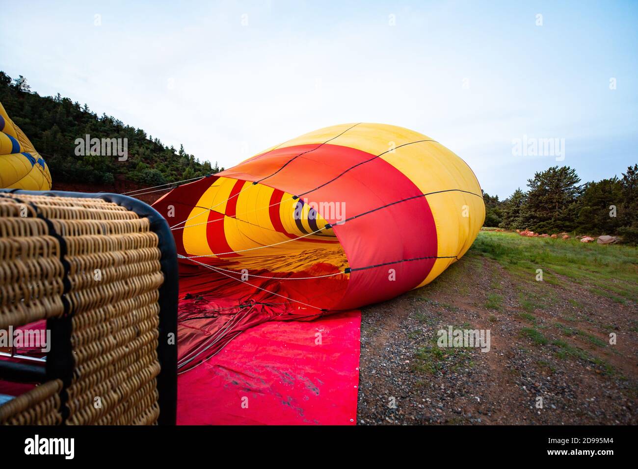 Yellow and Red Hot Air Balloon Inflating on the Ground at Sunrise Stock ...
