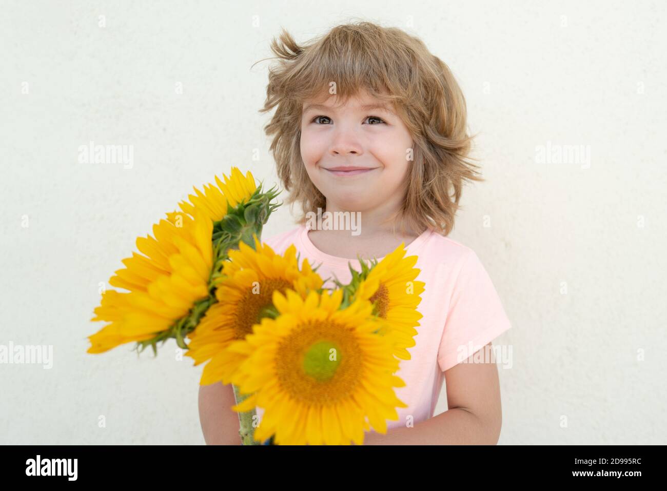 Summer portrait of kid with flowers. Smiling boy with bouquet of ...